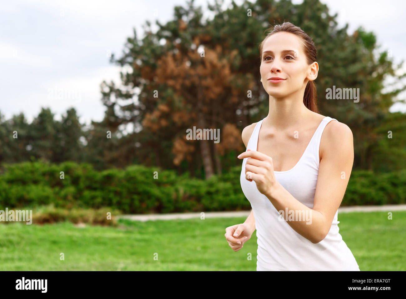 Running woman on background of park Stock Photo - Alamy