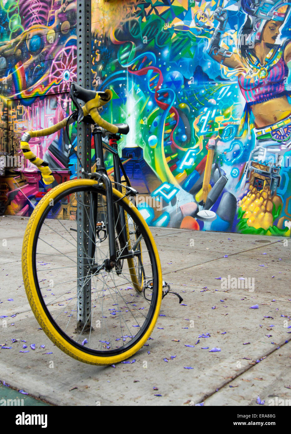 bicycle locked to pole by graffiti wall Stock Photo - Alamy