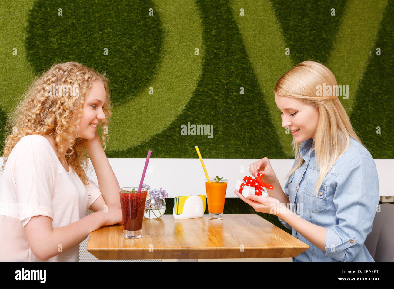 Two girls in cafe with present Stock Photo - Alamy