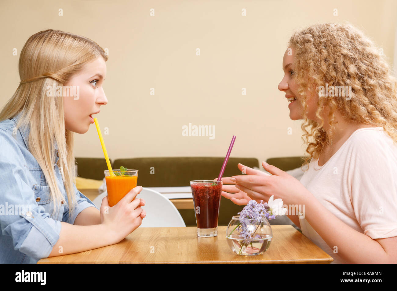 Two girls having conversation in cafe Stock Photo - Alamy