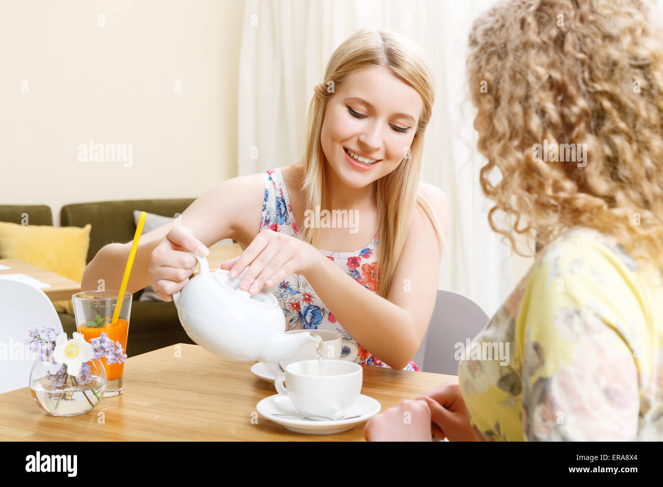 Pretty young girl pouring out tee Stock Photo - Alamy