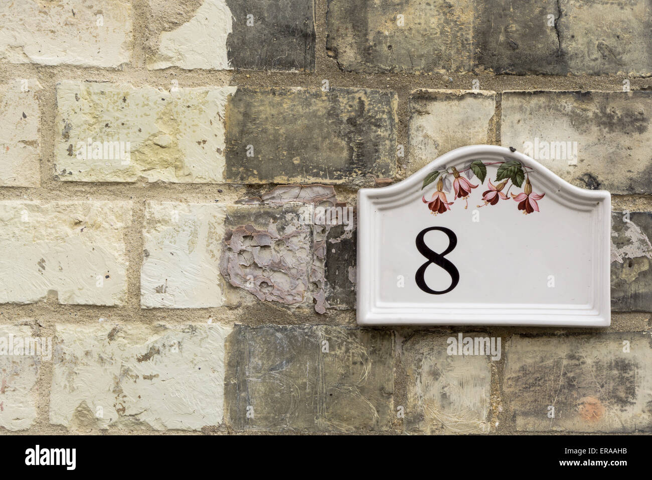 Eight 8 written on a mounted plate on a brick wall closeup Stock Photo ...