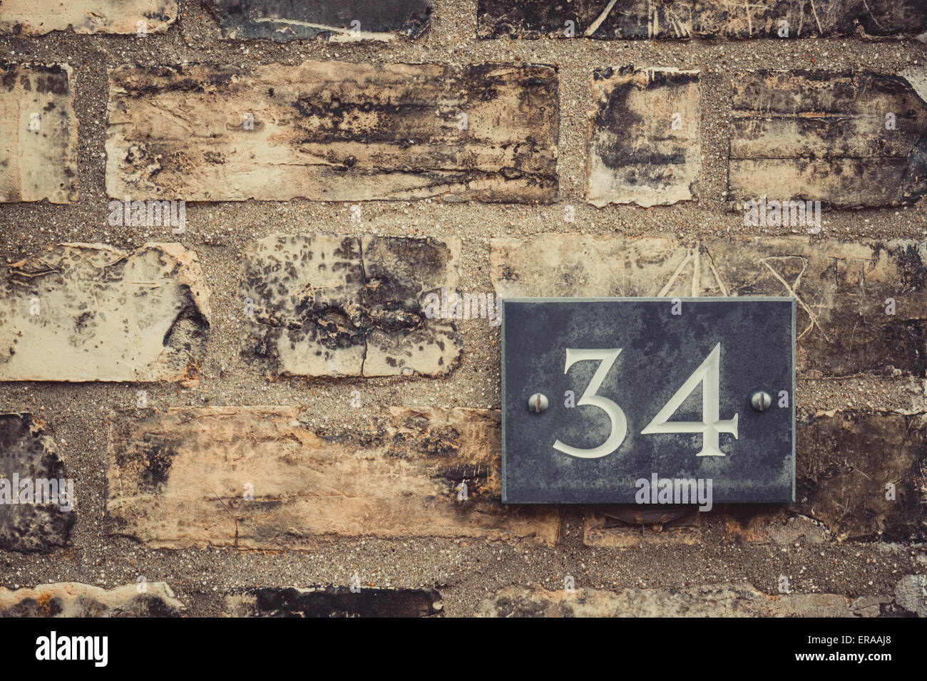 House number 34 thirty four plate on brickwall texture closeup Stock ...