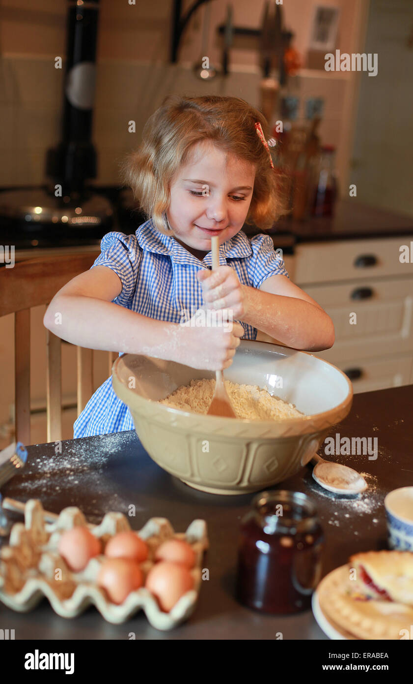 Pretty blonde haired girl mixing ingredients in a bowl for a pie Stock ...