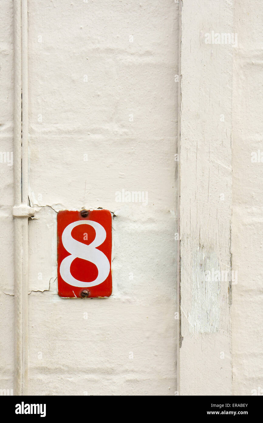 Red plate numbers Number 8 eight on white painted surface closeup Stock ...