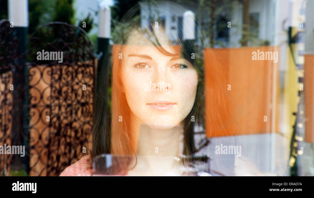 portrait of beautiful woman looking through window Stock Photo - Alamy