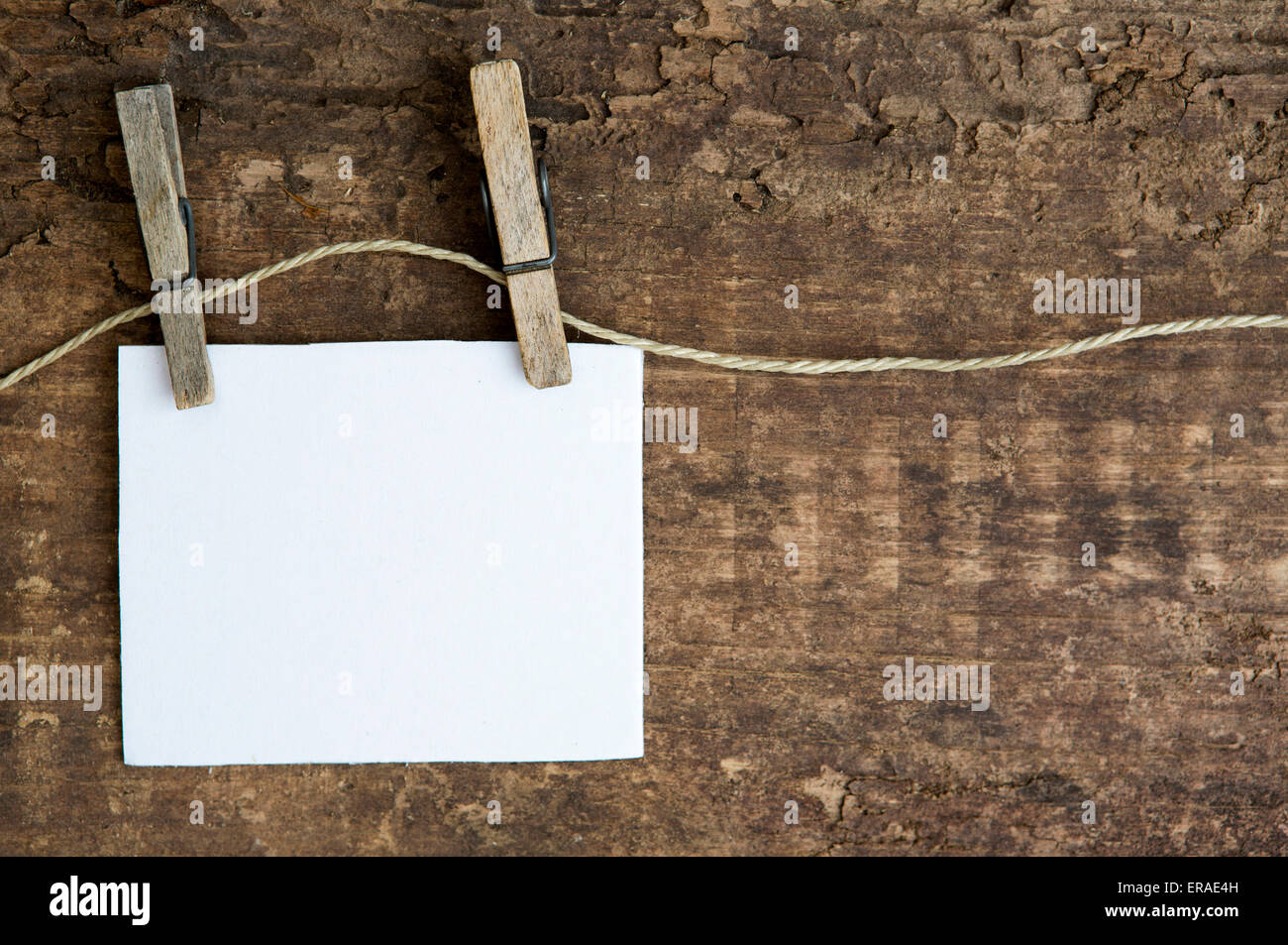 white paper sign hanging on clothesline with clothespins on rustic ...