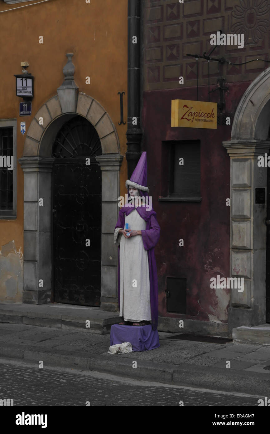 Male entertainer dressed as medieval lady, purple pointed hat, white ...