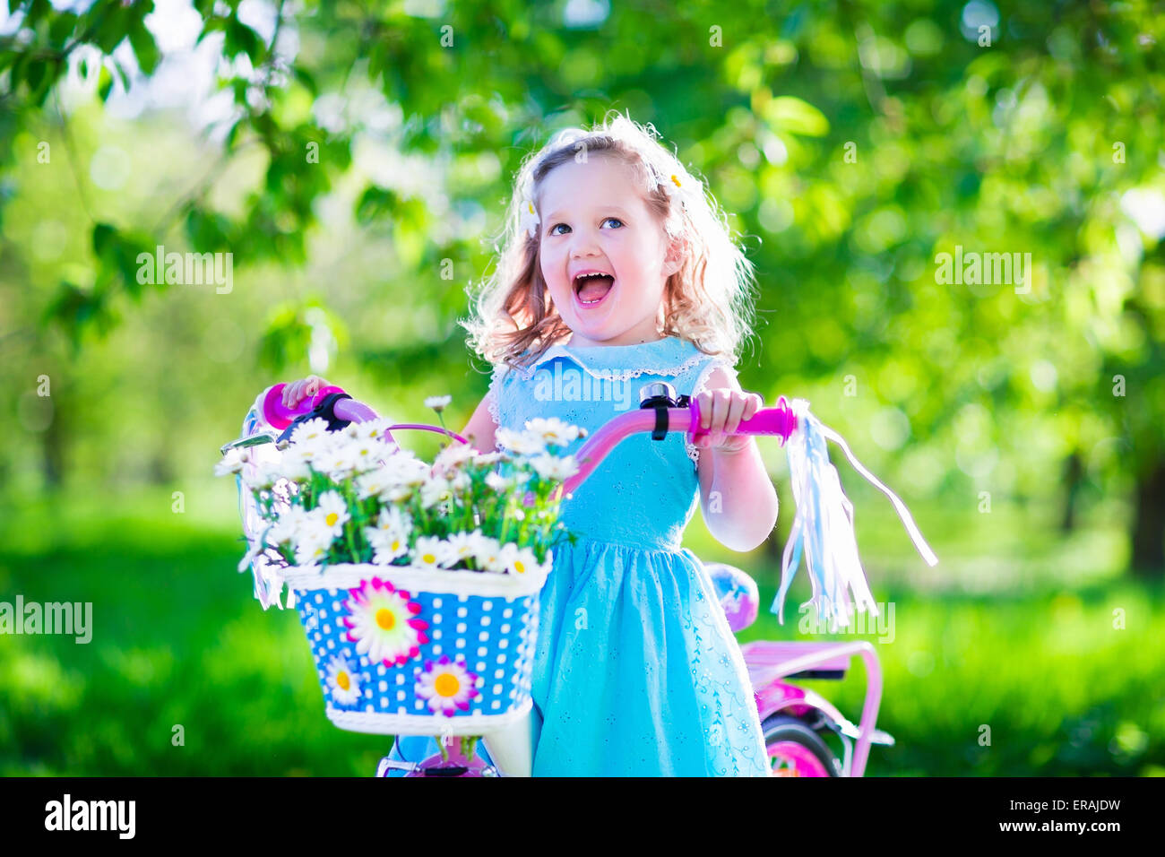 Happy child riding a bike. Cute kid biking outdoors. Little girl in a ...
