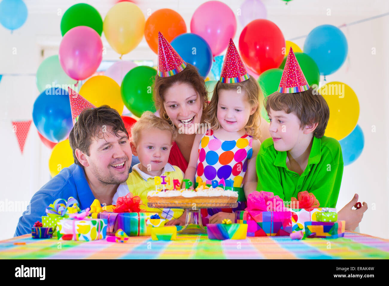 Happy family celebrating kids birthday. Parents and three children ...