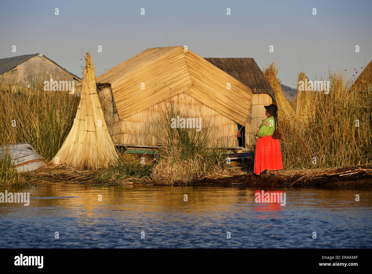 Uros Indian woman by house made of tortora reeds on floating island ...