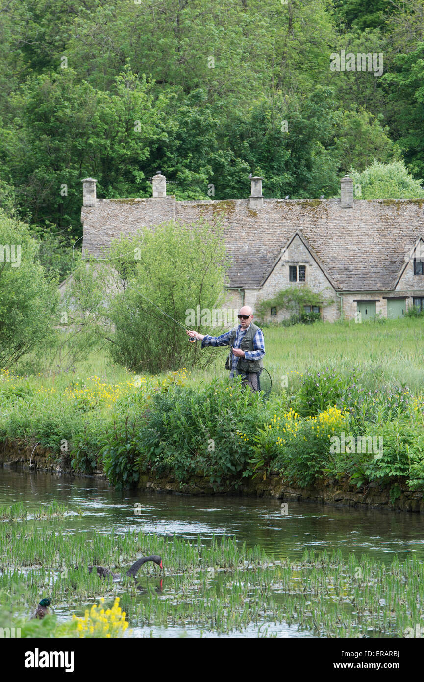 Man fly fishing on the River Coln in front of Arlington row, Bibury ...