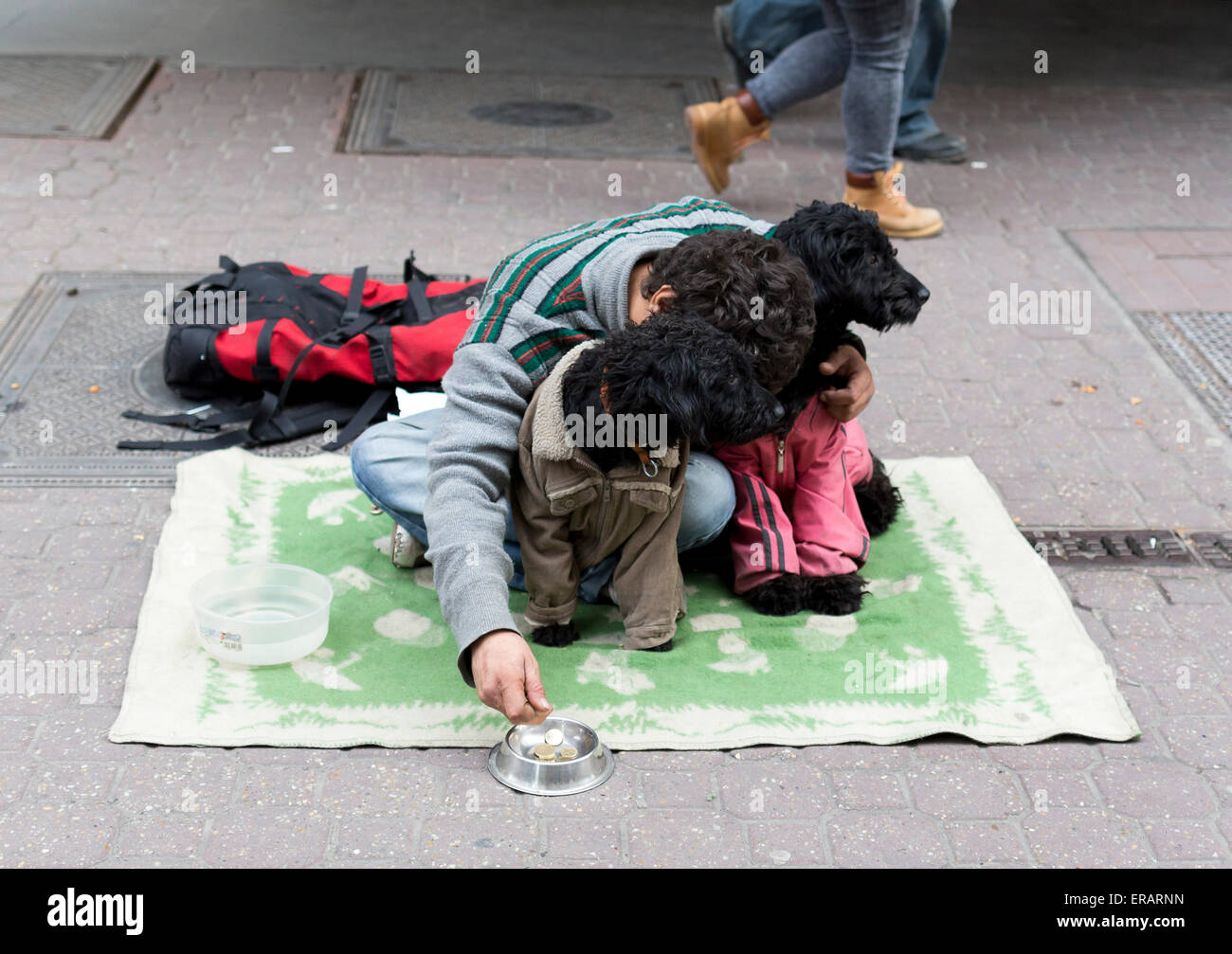An young man is begging on the ground of a main street in Budapest ...