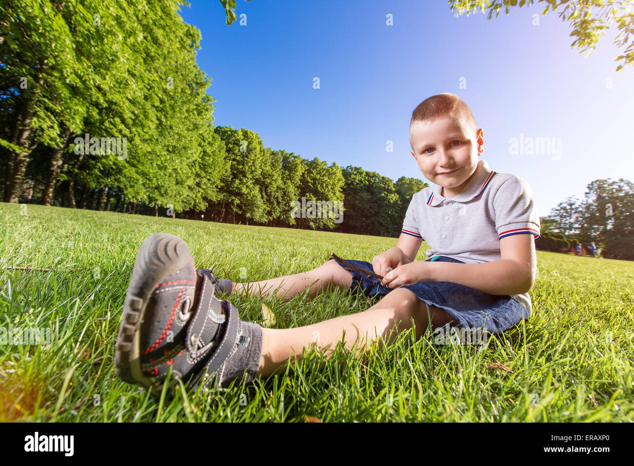 happy little boy laying on the grass Stock Photo - Alamy