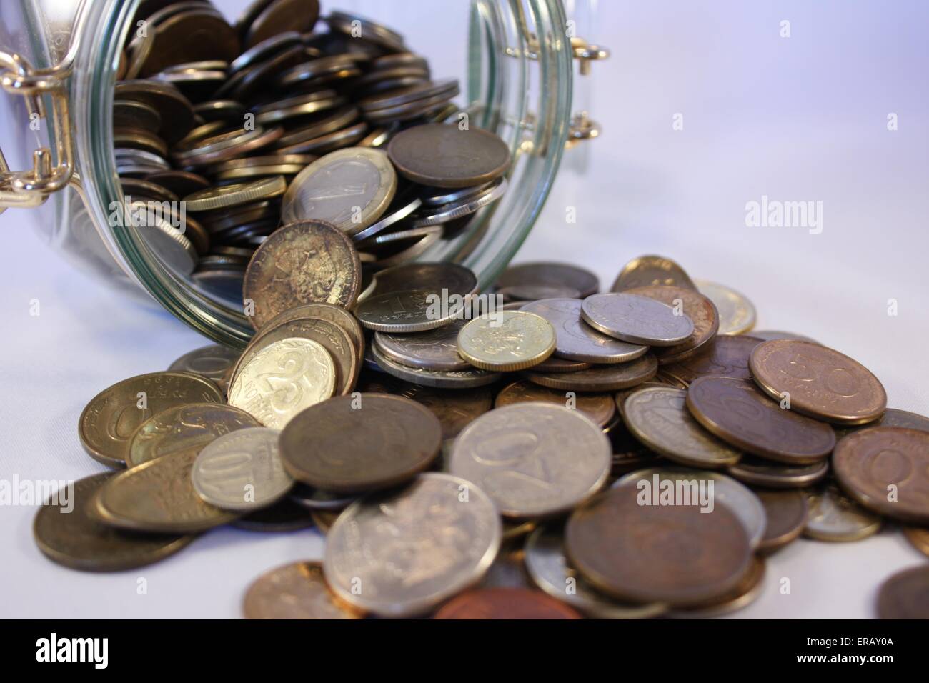 Coins spill out of the jar Stock Photo - Alamy
