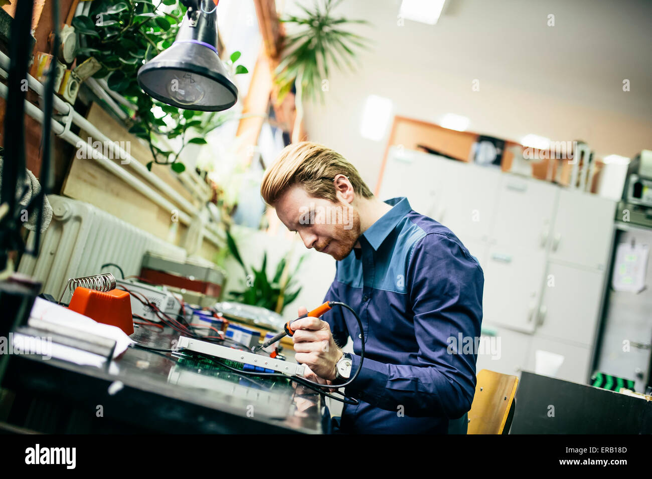 Young man in electronics workshop Stock Photo - Alamy