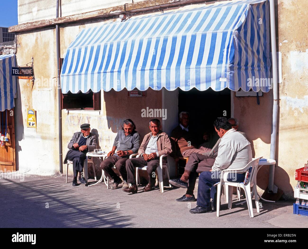 Cypriot men sitting outside a bar in the village centre, Neo Chorio ...