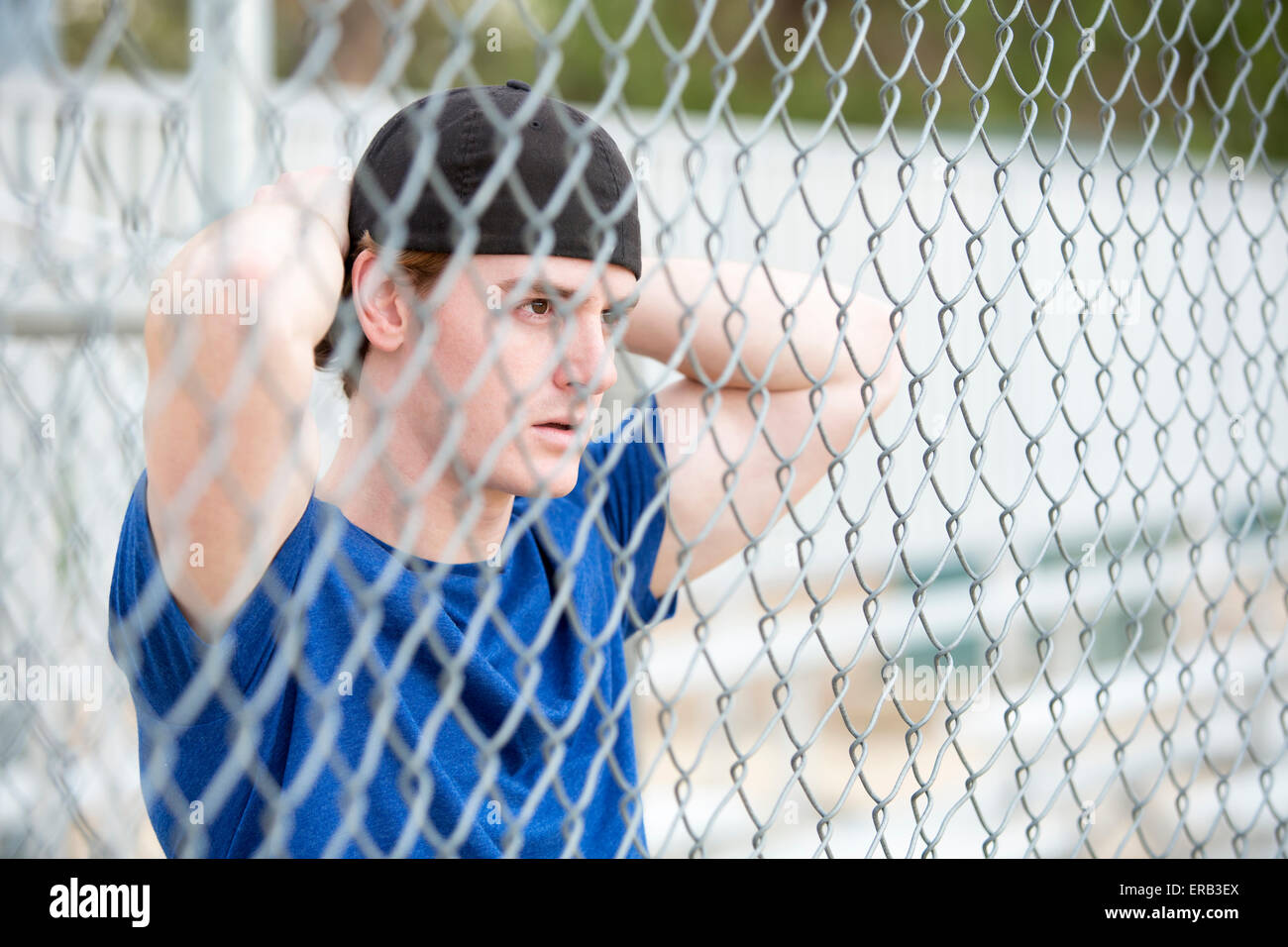 young man standing behind a fence Stock Photo - Alamy
