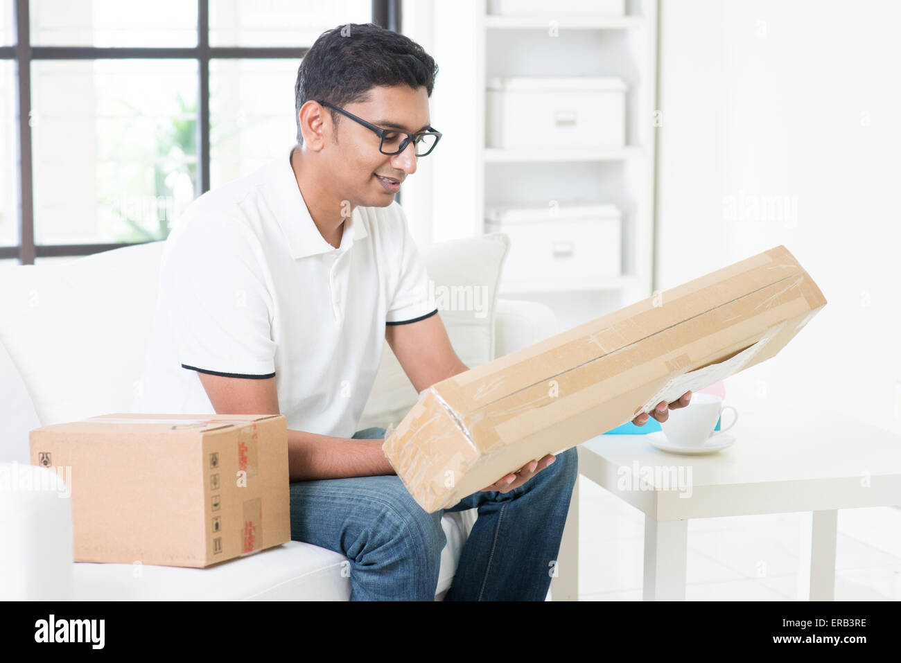 Indian guy received an express parcel and checking the box at home ...