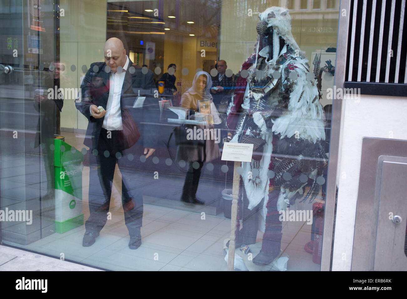 Artwork of a large bald man holding a tiny chick in an office window ...