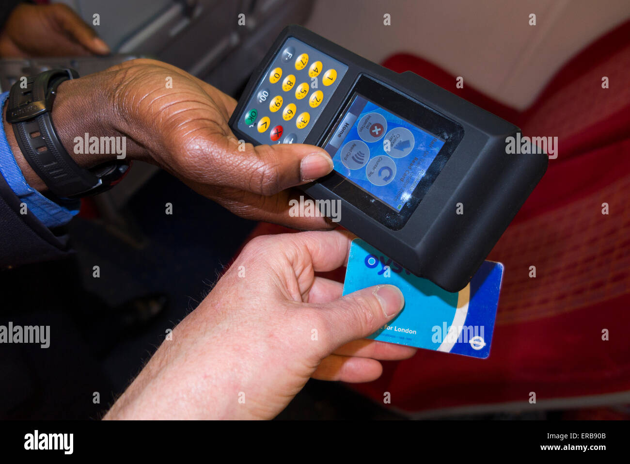 Inspector checks / reads Oyster Card ticket with reader on SW Trains ...