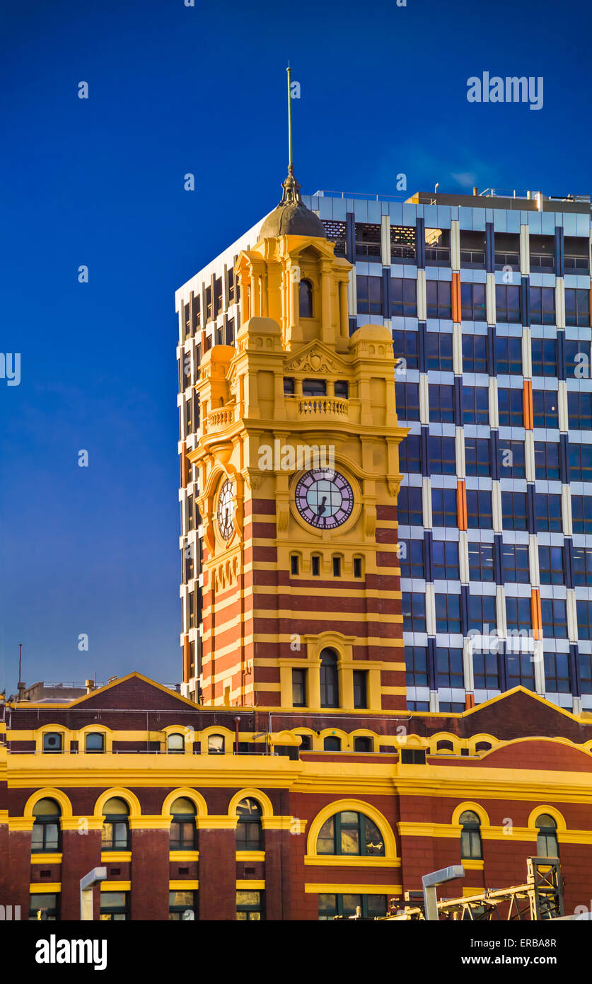 Close up of Flinders Street Station clocktower against office buildings ...