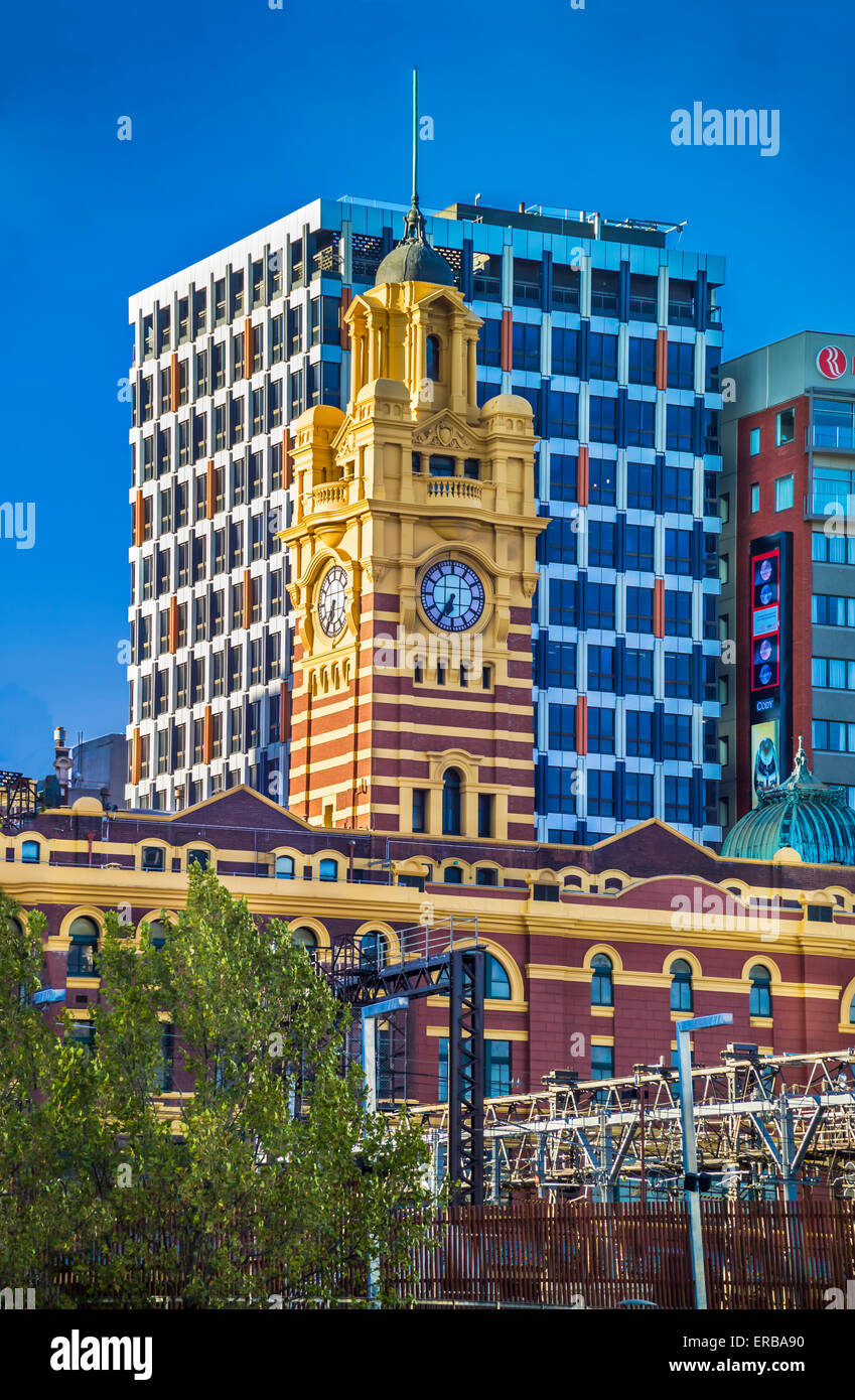 Close up of Flinders Street Station clocktower against office buildings ...