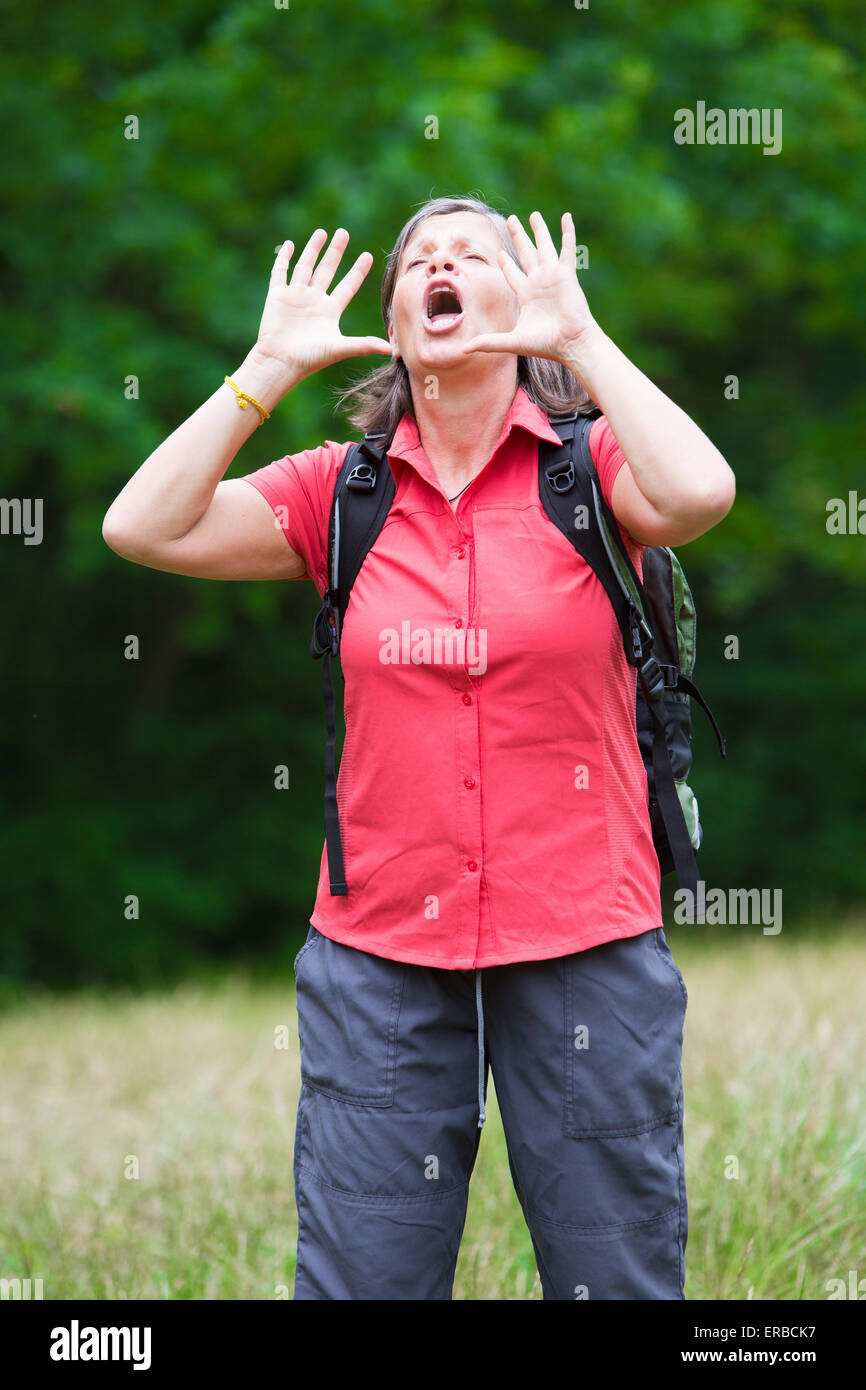 older woman is hiking in nature and shouting Stock Photo - Alamy