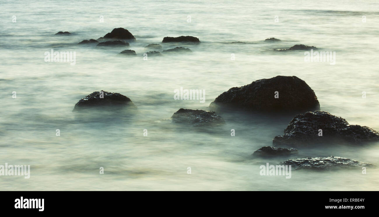 rocks in the sea surf, long exposure Stock Photo - Alamy