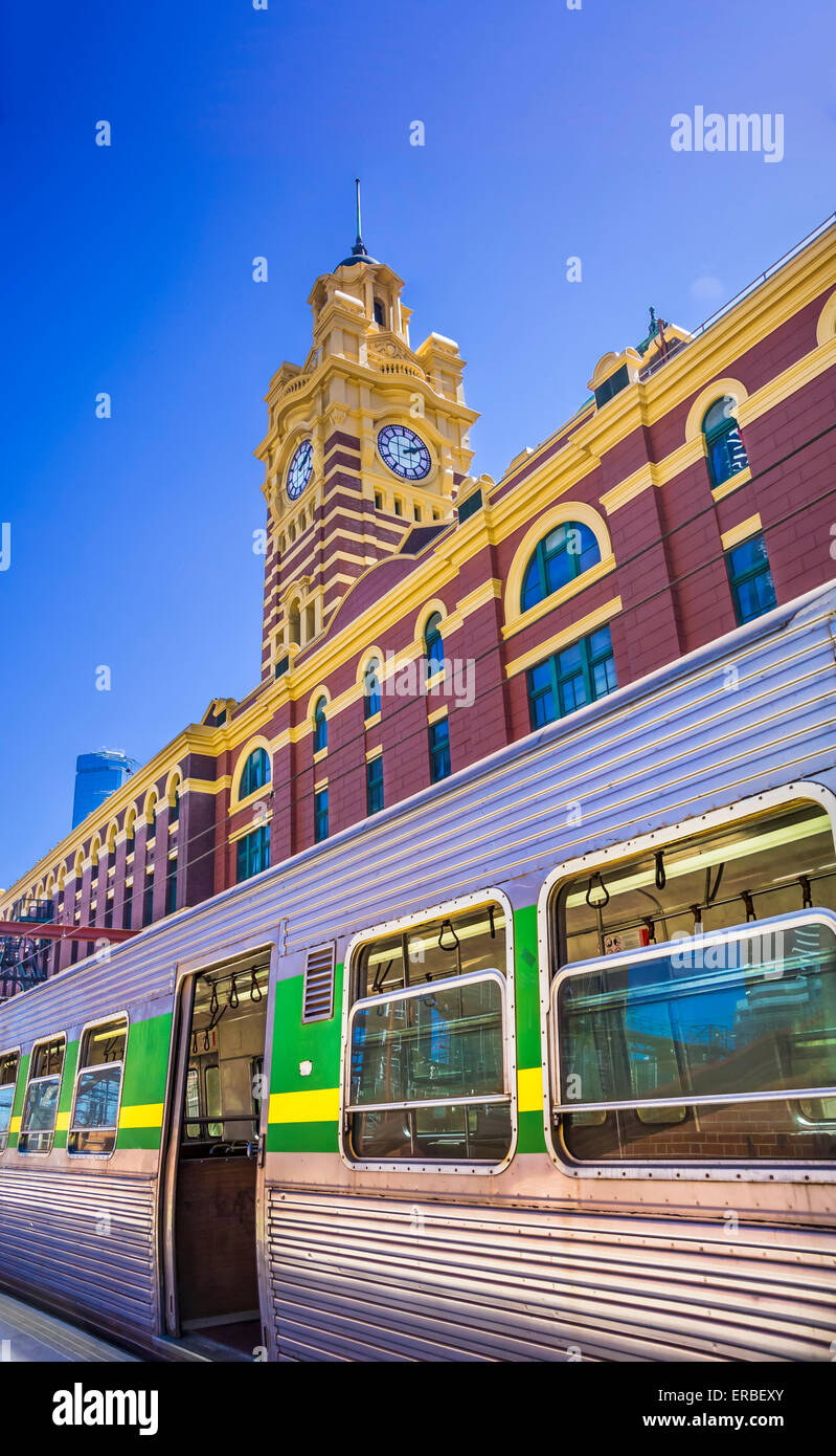Modern silver train pulling up at iconic Flinders Street Station ...