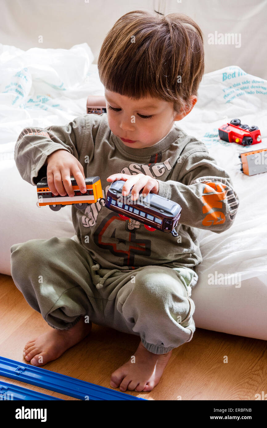 Caucasian child, boy, 3-4 year old, crouching down indoors at home on ...