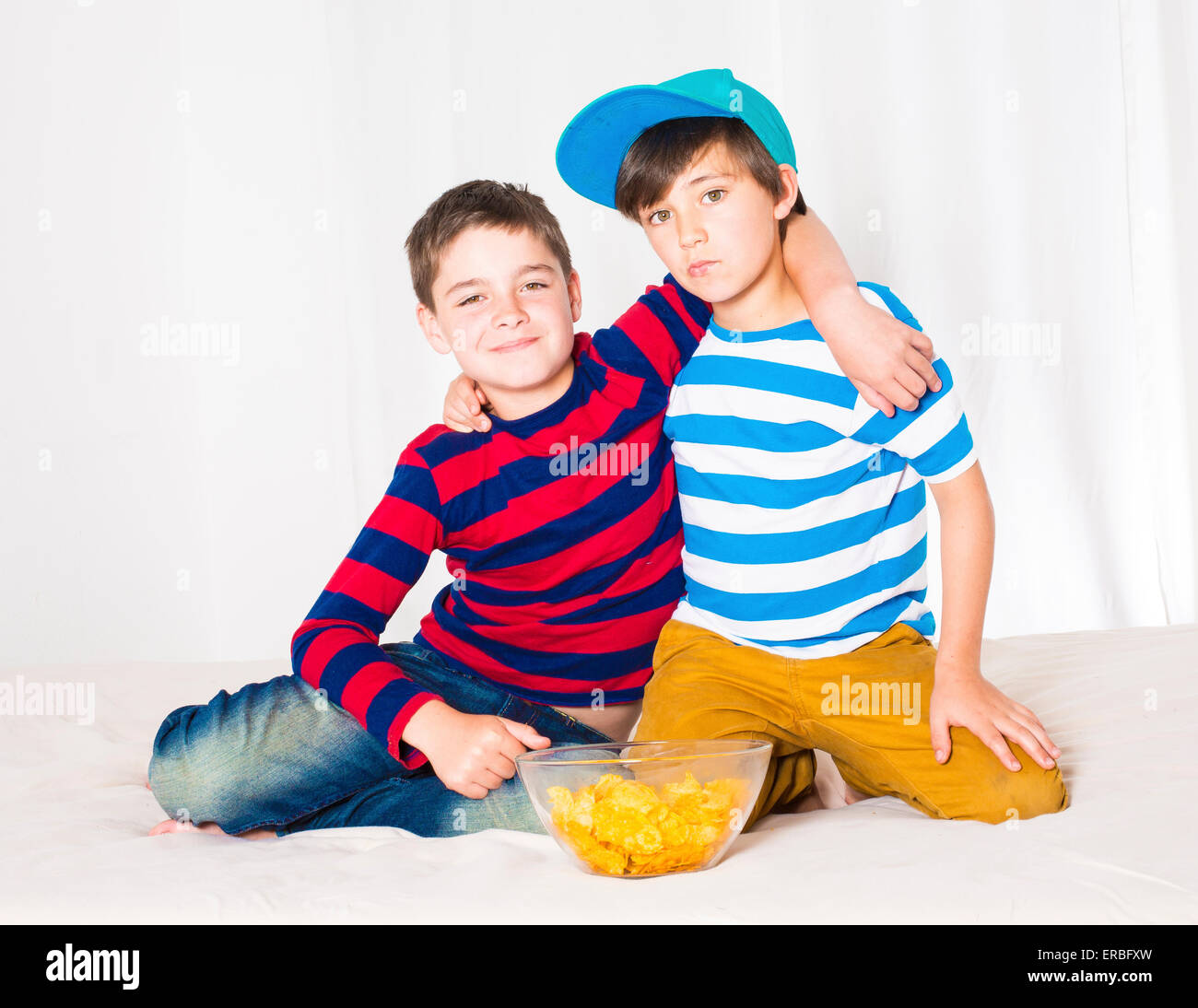 two kids in bed eating potato chips Stock Photo - Alamy