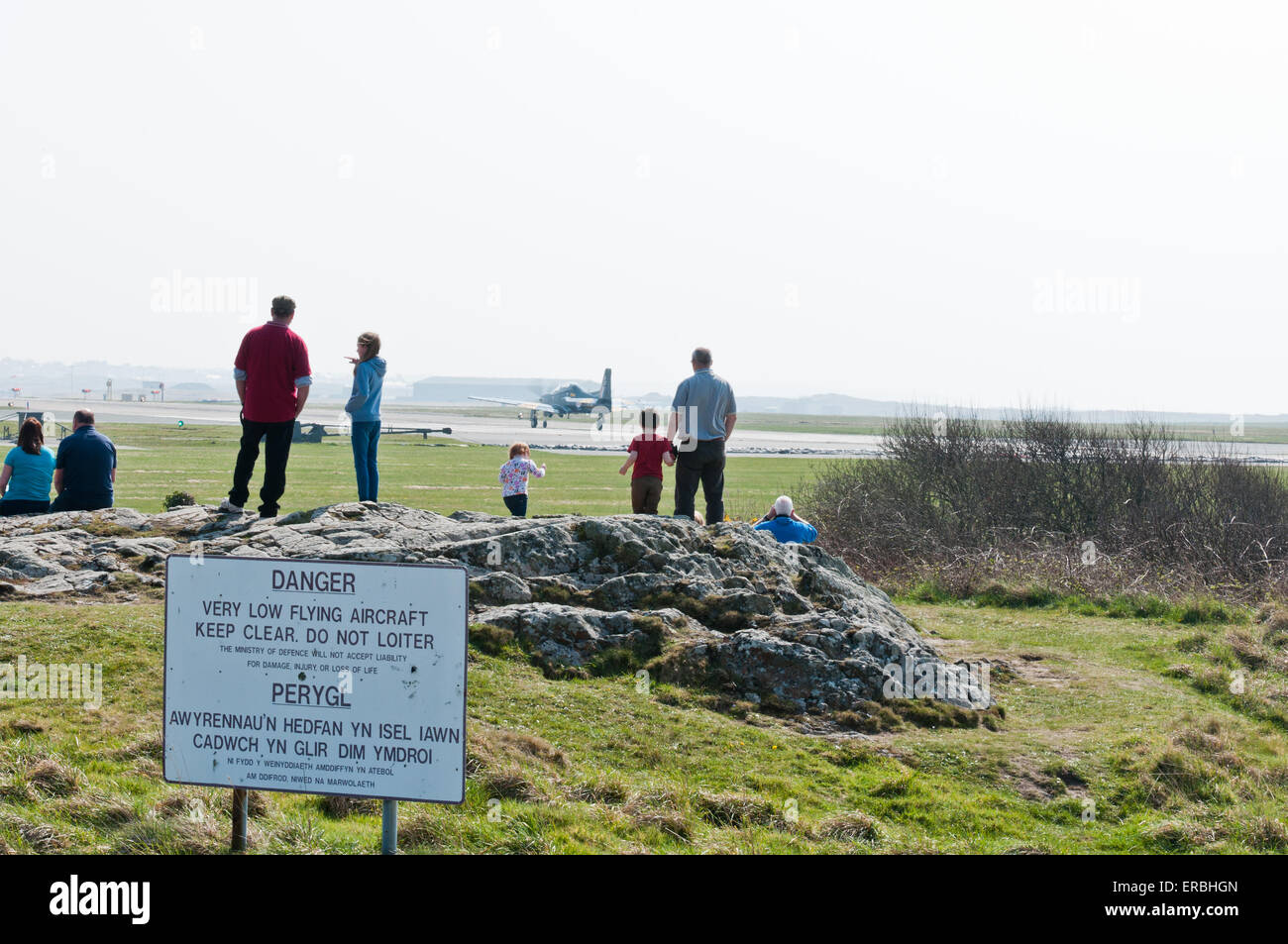 Aircraft spotters loitering next to the sign warning people to stay ...