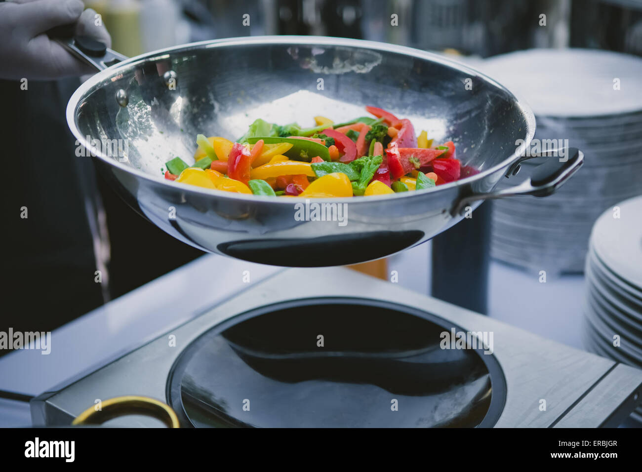 Chef cooking vegetables in wok pan. Shallow dof Stock Photo - Alamy