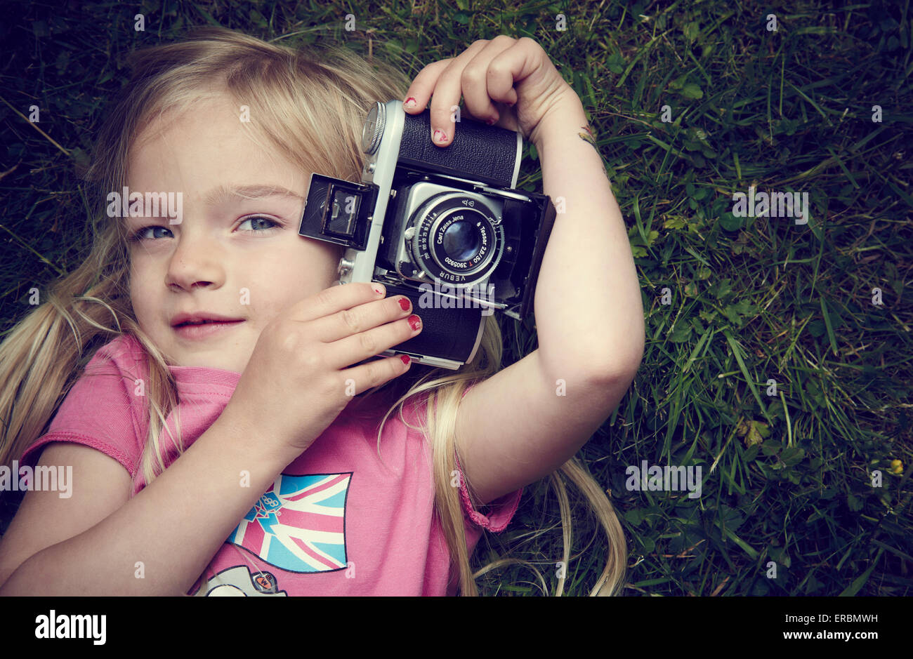Portrait of little girl taking picture using vintage old retro film ...