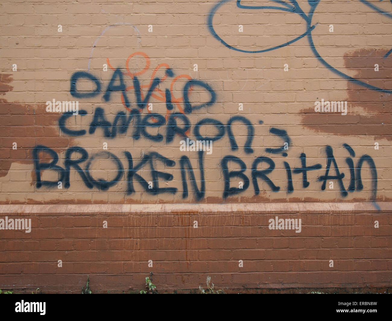 Political graffiti spray painted on a wall proclaiming "David Cameron's ...