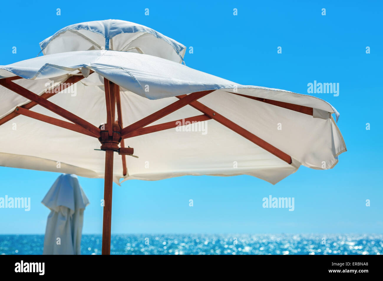 Big white parasol on a background of bright blue sky close-up. Beach ...