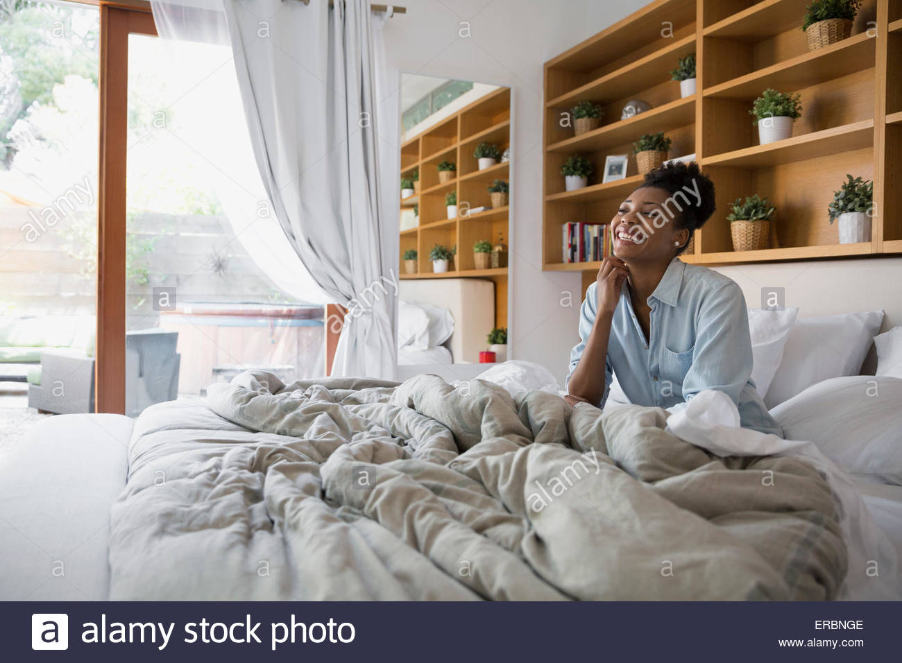 Smiling woman sitting in bed Stock Photo - Alamy