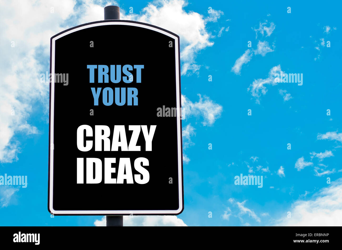 TRUST YOUR CRAZY IDEAS motivational quote written on road sign isolated ...