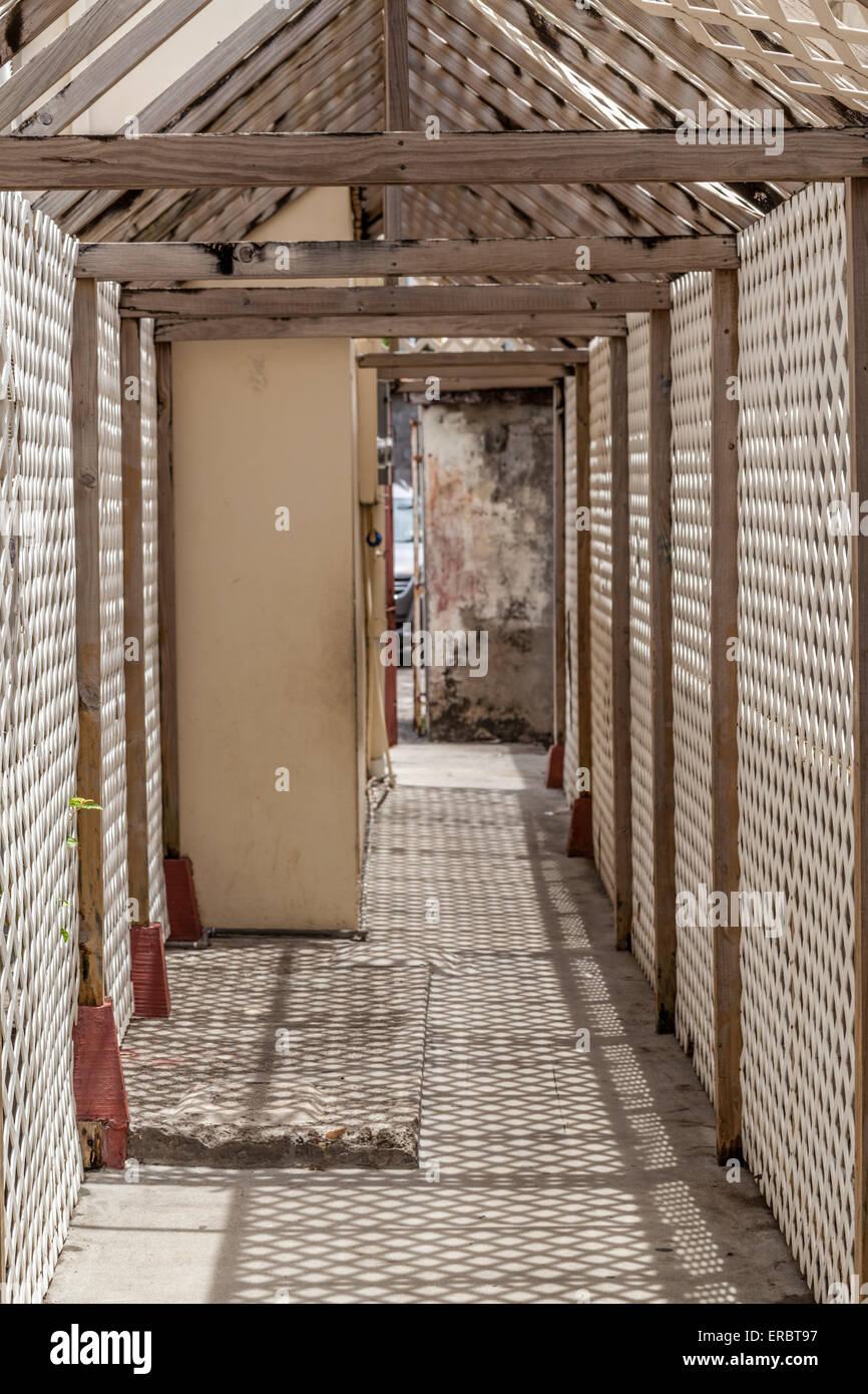 Looking straight through a brightly lit corridor flanked by lattice ...