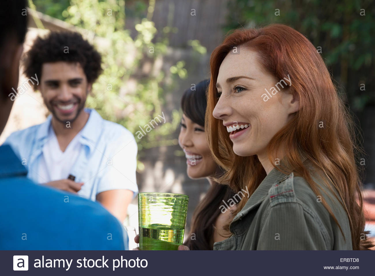 Smiling friends talking on patio Stock Photo - Alamy