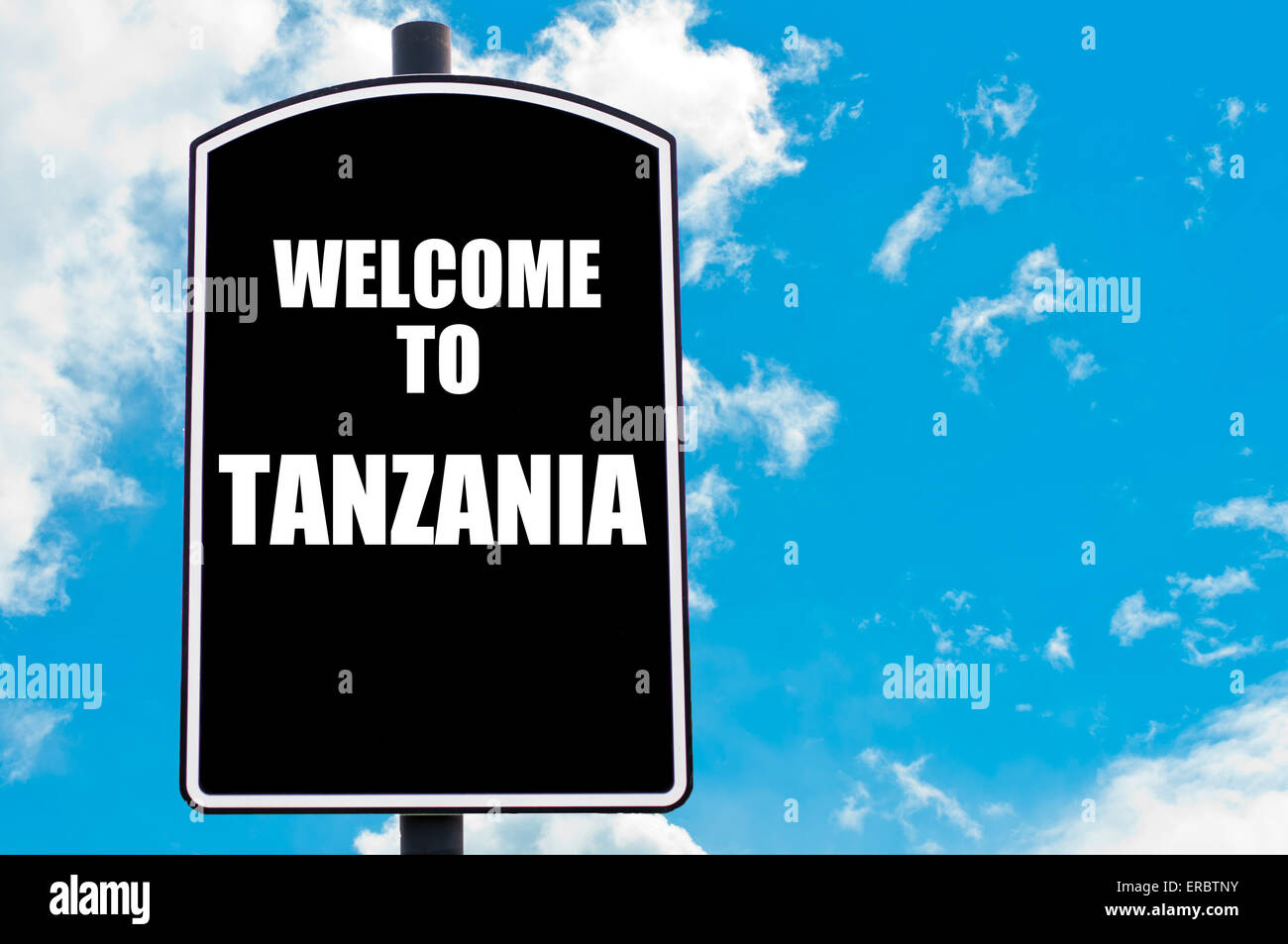 Black road sign with greeting message WELCOME TO TANZANIA isolated over ...