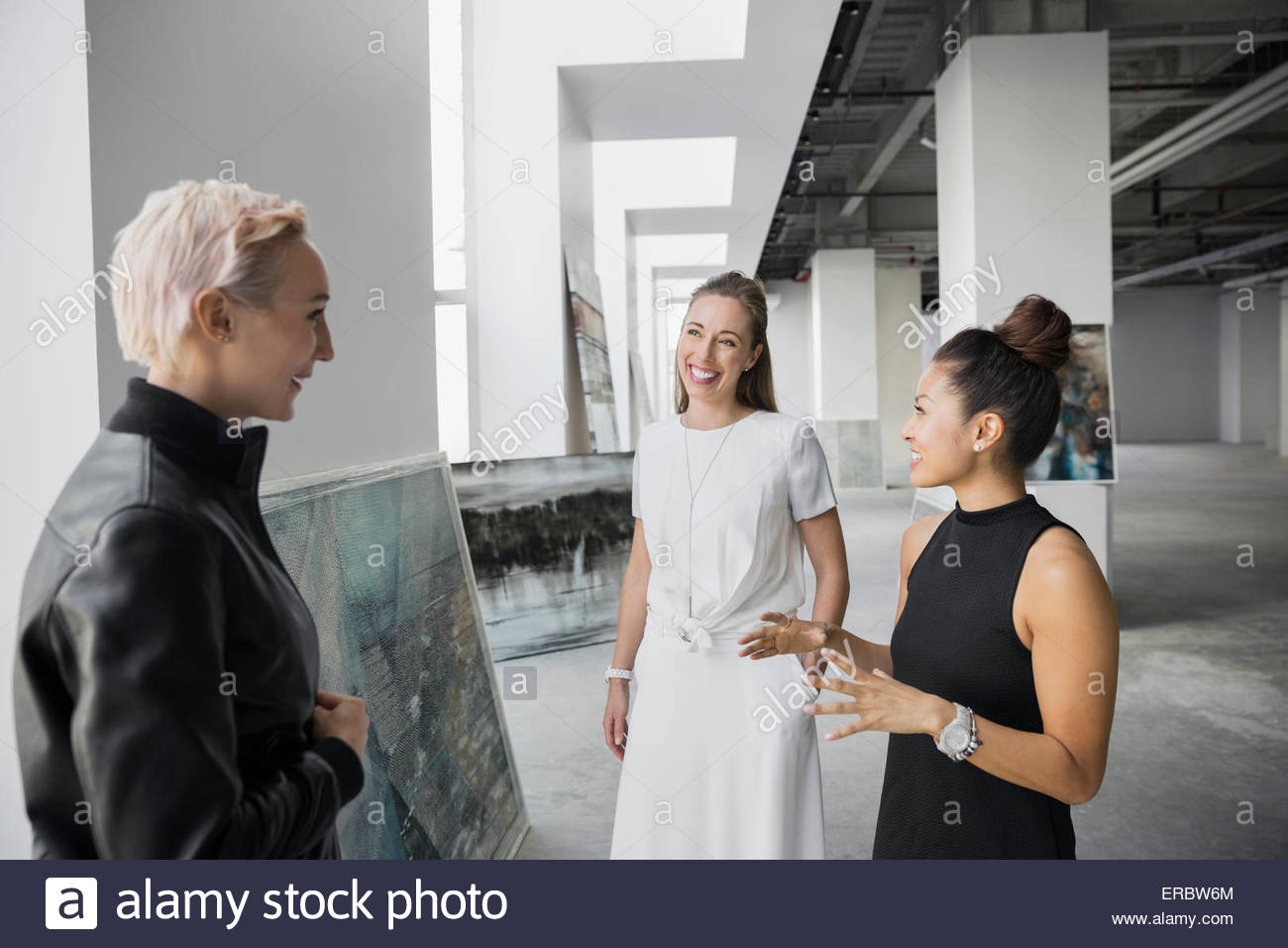 Artist and art dealers discussing paintings art gallery Stock Photo - Alamy