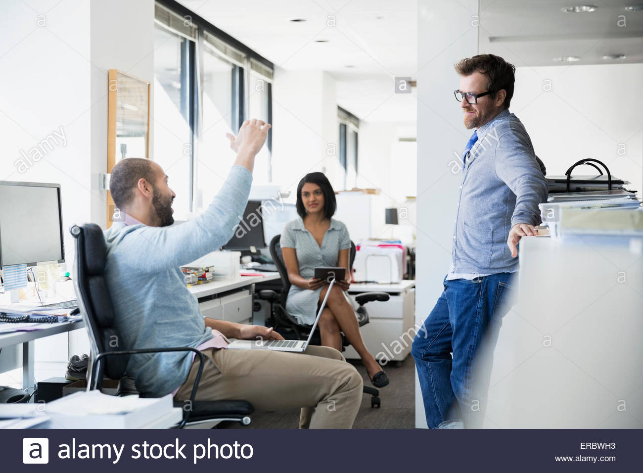 Businessman gesturing and explaining to co-workers office Stock Photo ...