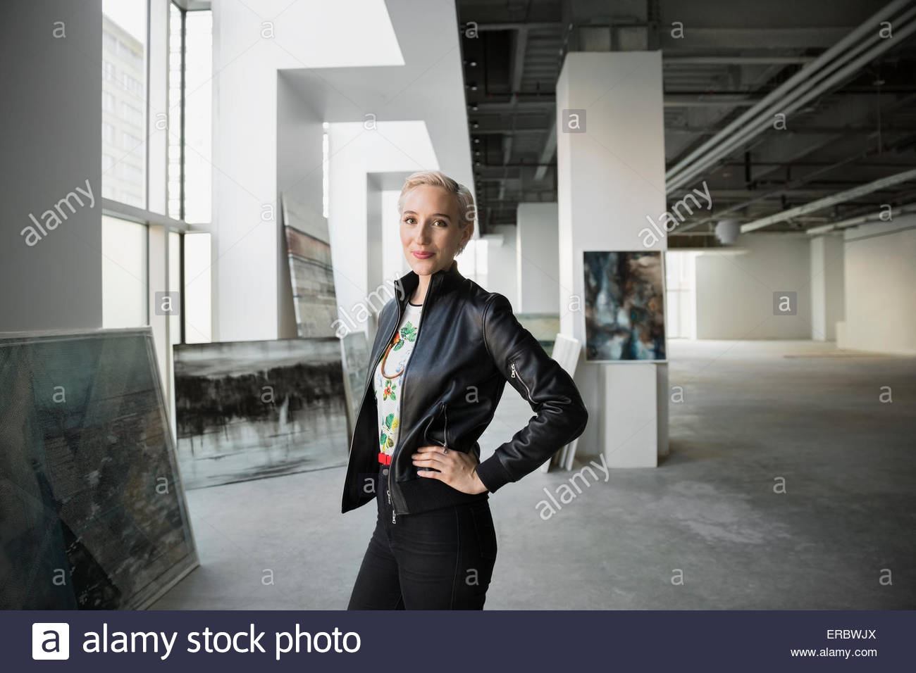 Portrait confident artist with paintings in art gallery Stock Photo - Alamy
