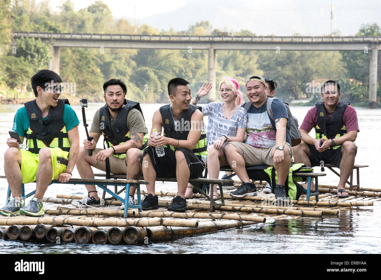 A group of friends traveling on a raft going down a river in Bangkok ...