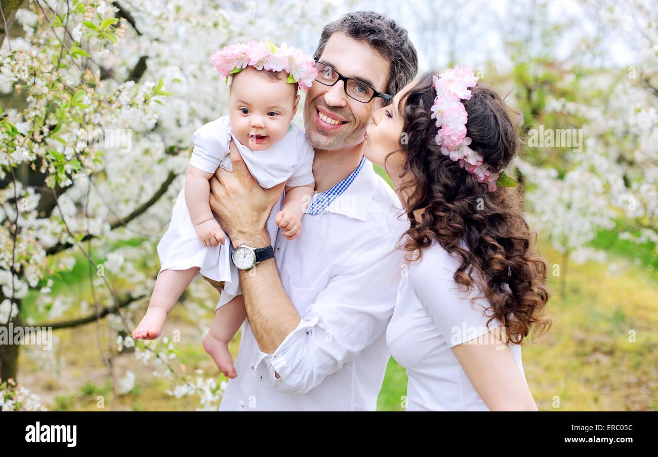 Cheerful family in the spring apple tree orchard Stock Photo - Alamy