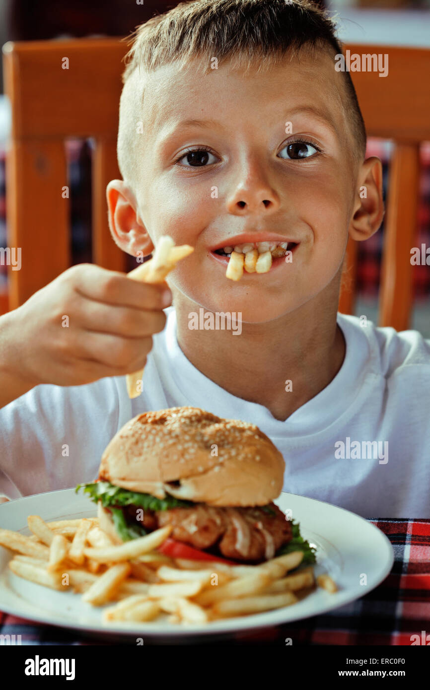 little cute boy 6 years old with hamburger and french fries maki Stock ...