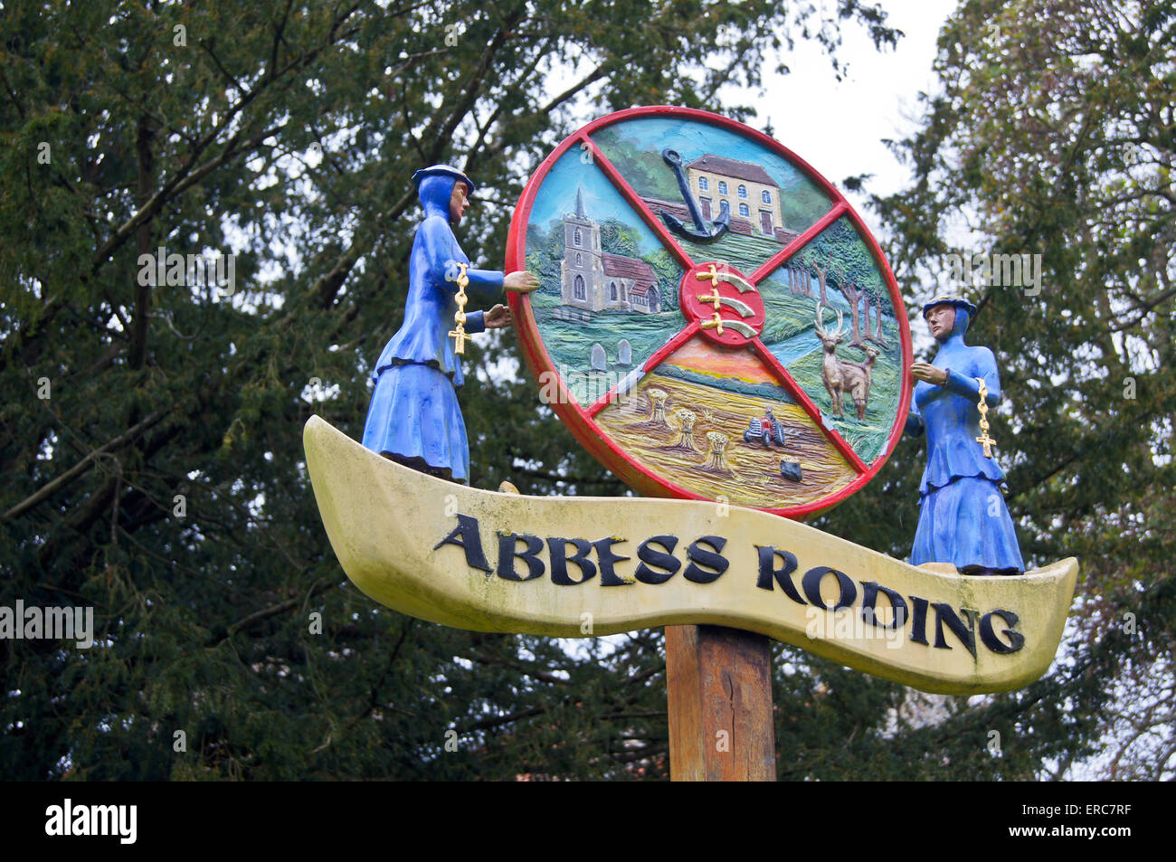 Carved wooden village sign showing two abbesses in blue vestments ...