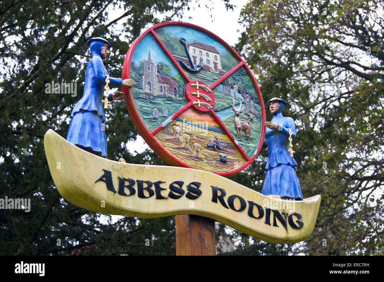 Carved wooden village sign showing two abbesses in blue vestments ...